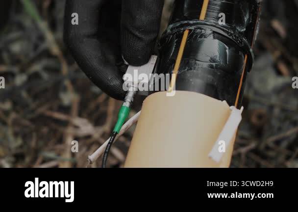 A close-up of an engineers gloved hands inspecting a plastic gas pipe ...