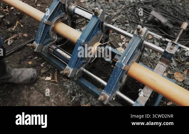 Plastic pipe welding equipment in operation. Joining two pipe sections ...