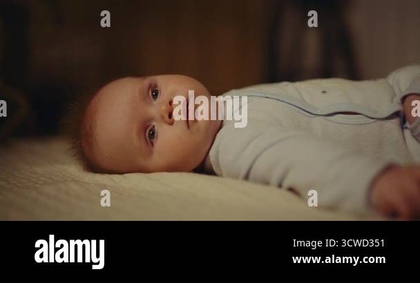 A close-up portrait of a newborn baby boy with a smiling face. Strong ...