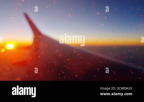 Vibrant airplane wing silhouette at sunset with a glowing horizon and ...