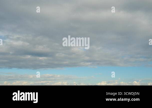 Soft white and gray cumulus clouds drifting in sky generating peaceful atmosphere. Background of ...