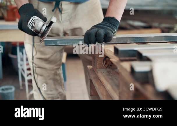 Grinding of welded joints. A man is processing a metal product with an ...