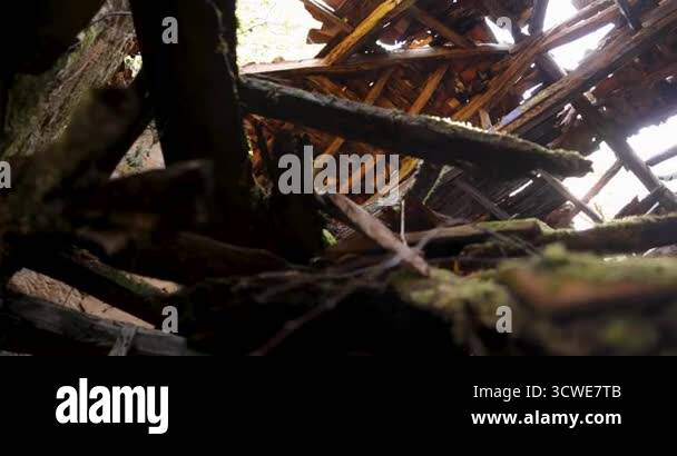A dilapidated building with a collapsed roof. There are lots of holes ...