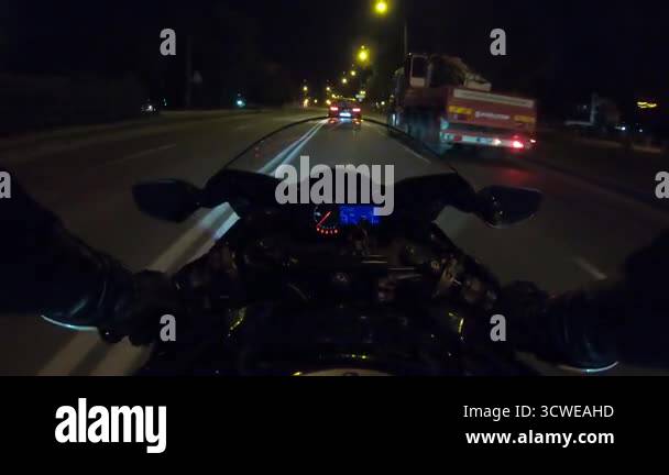 Biker navigating through vibrant city streets at night, showcasing ...