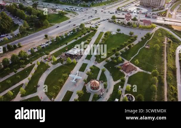 Aerial view of a vibrant city park with a carousel, airplane, cafe ...
