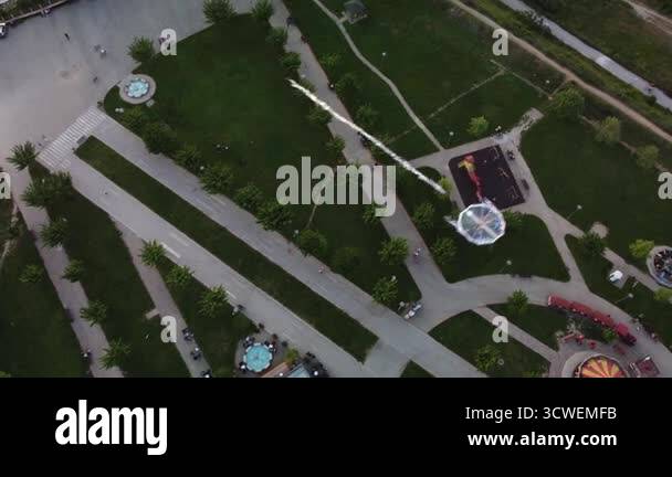 Aerial view of a colorful kite soaring above a park with a playground ...