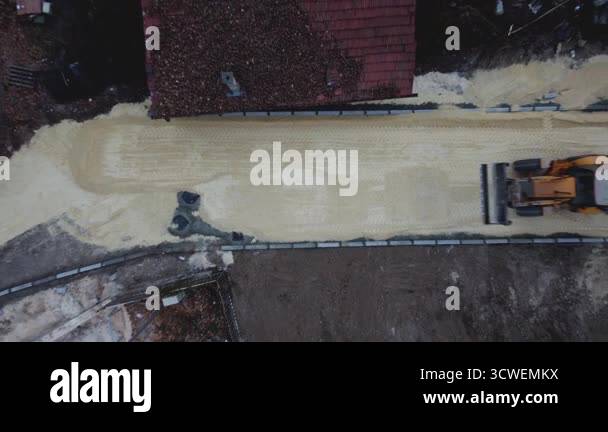 A bulldozer levels sand for a new road construction. The aerial view ...
