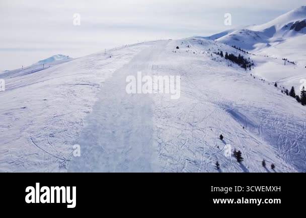 Skiers skiing on slopes. Sunny day over ski piste with many ski tracks ...