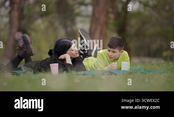 Young friends share a joyful moment in a lush meadow, embracing and ...