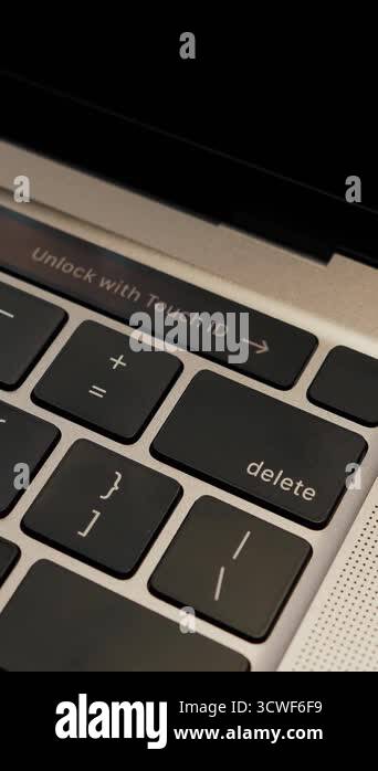 Man unlocking laptop computer with touch ID close up of laptop keyboard ...