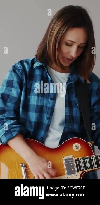 Young attractive female with electric guitar practicing songs. Woman ...