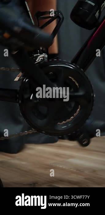 Sportive female legs are spinning pedals indoor on bicycle simulator ...