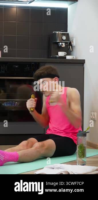 Young man with mustache in pink top practicing boxing exercises with ...