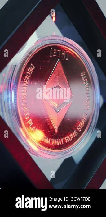 Shining golden metal ethereum ETH coin in frame rotating on white ...