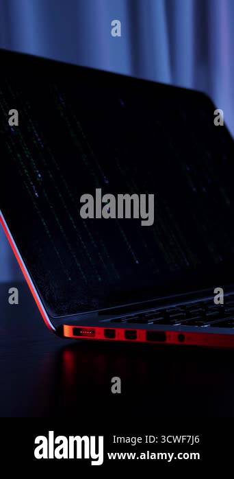 Laptop computer in dark room with red lights, close up. Opened laptop ...