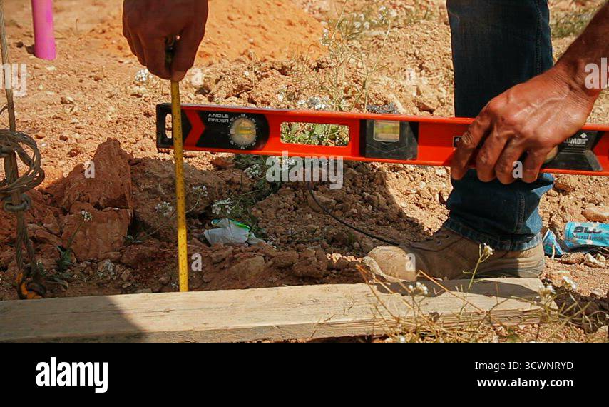 Construction worker checking the depth of the hole at a construction ...