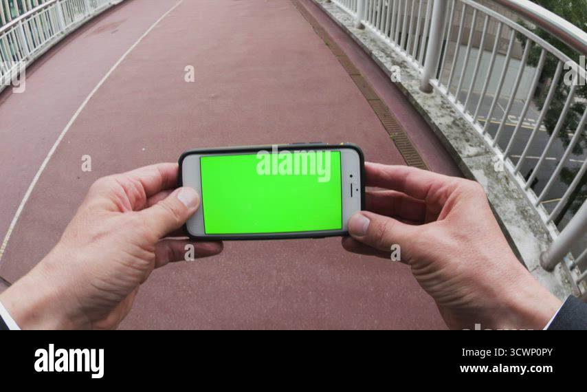 Personal perspective of a man using a smartphone with a green-screen ...