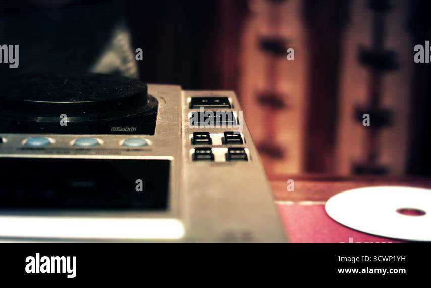 DJ at a console booth spinning and touching mixer faders and knobs ...