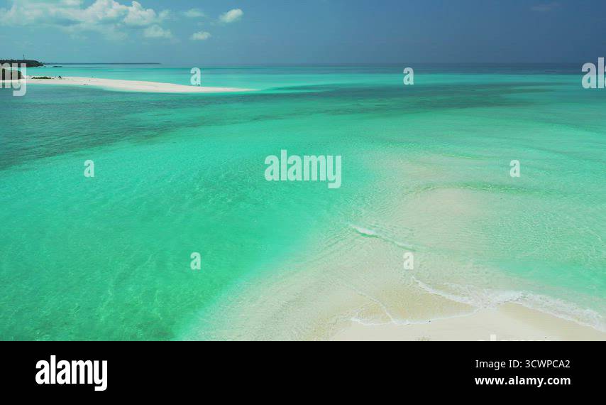 Caribbean waves disolves gently into foam at the shore of a white sand ...