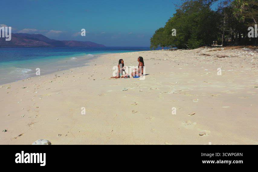 Two beautiful caucasian girls in bikini sunbathing, hanging and playing ...