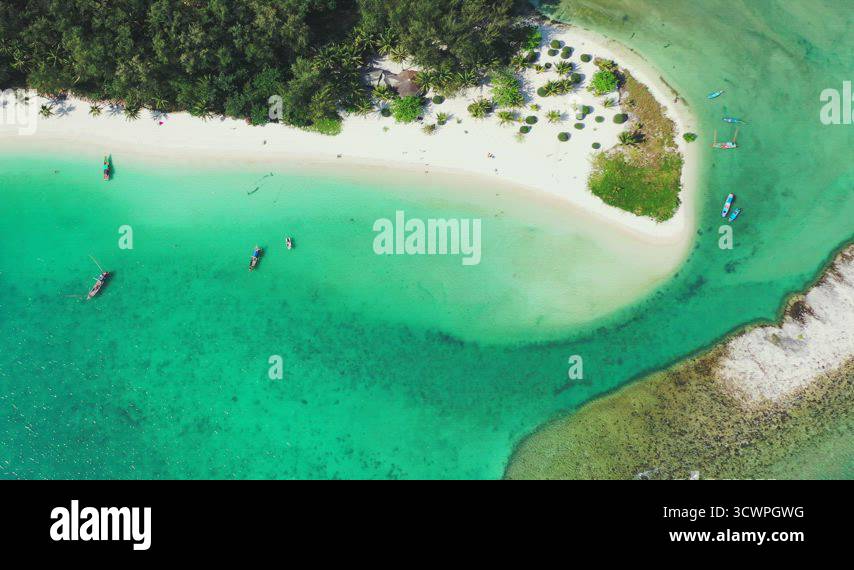 A shallow lagoon encircled by a reef leading to a stretch of powdery ...