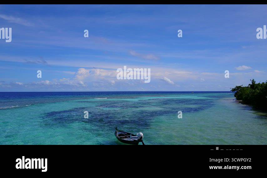 Small boat anchored at the beach on a sunny afternoon in Maldives Stock ...