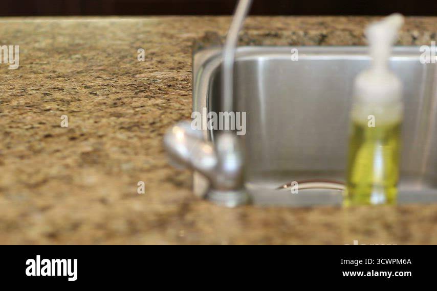 Pan of Woman At Home Rinsing Off Dishes in a Stainless Steel Sink Stock ...