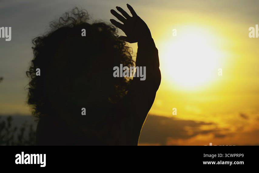 Goodbye hand gesture against sunset. Romantic sunset farewell female ...
