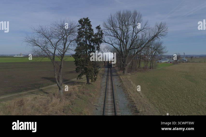 Aerial view of a restored steam locomotive and passenger cars traveling ...