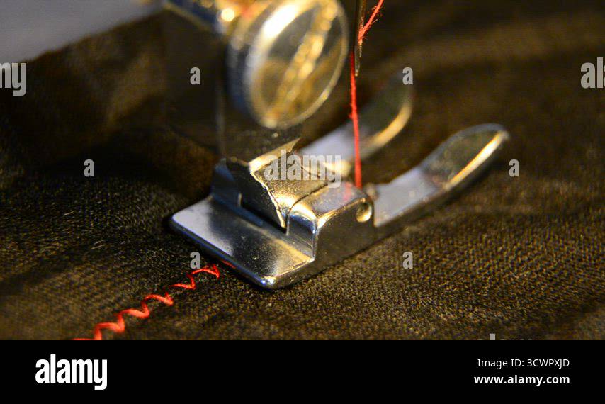 sewing machine and item of black clothing with a contrast red thread ...