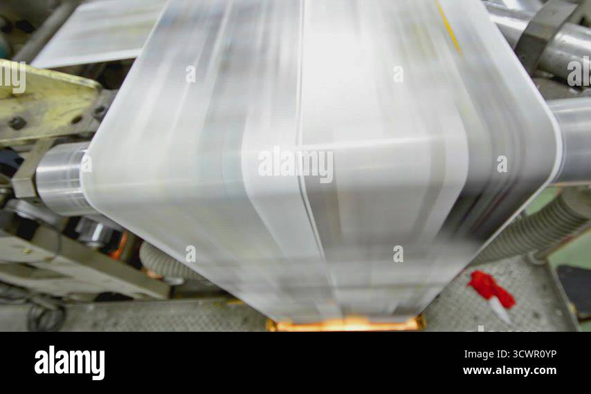 Printing press production line with machine parts moving rhythmically ...