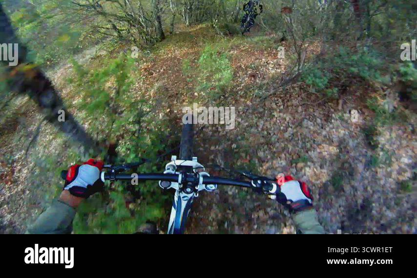 Extreme Mountain Bike race. View from handlebars of man on bike on dirt ...