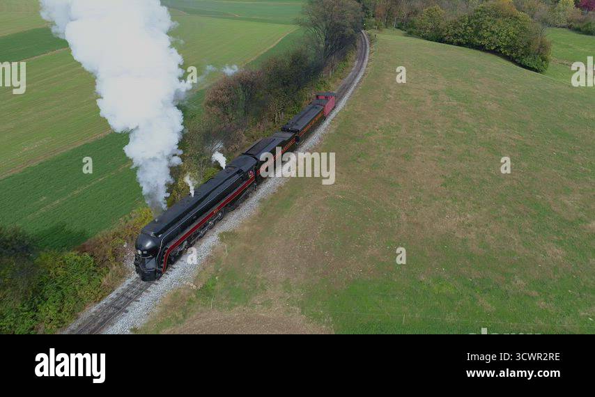 Aerial view of an antique restored steam locomotive traveling thru ...