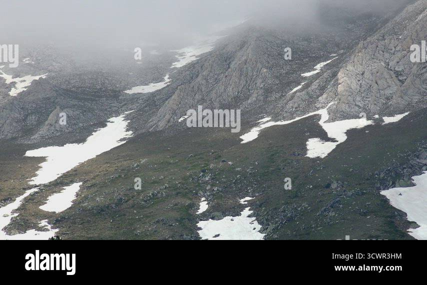 Italian Alps mountain fog covered peak with spring snow. UHD 4K stock ...
