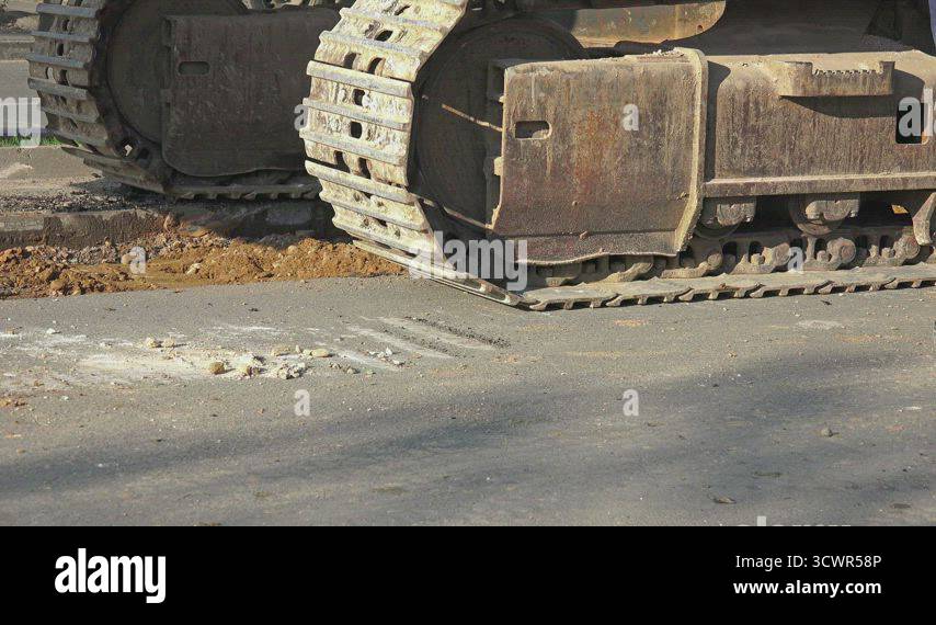 Detail of continuous track of a backhoe tractor works on a construction ...