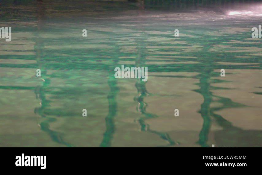 Swimming pool surface with reflection. Dark atmosphere background loop ...