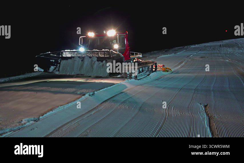 4K red snowcat ratrac tractor in a ski resort prepares skislope at ...