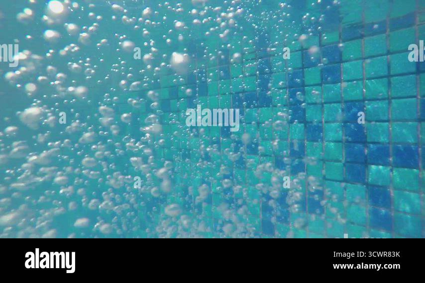 Bubbles rising to the surface. Slow motion. Air bubbles in clear blue ...