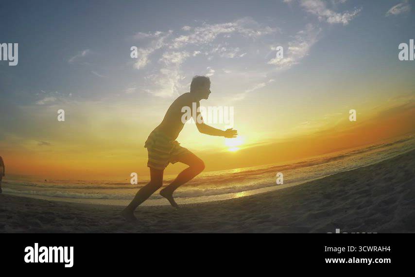 traceur shows various jumps while running on beach sunset sand ...