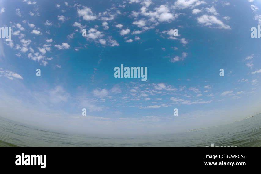 4k beautiful time lapse of big white clouds moving over a ocean water ...