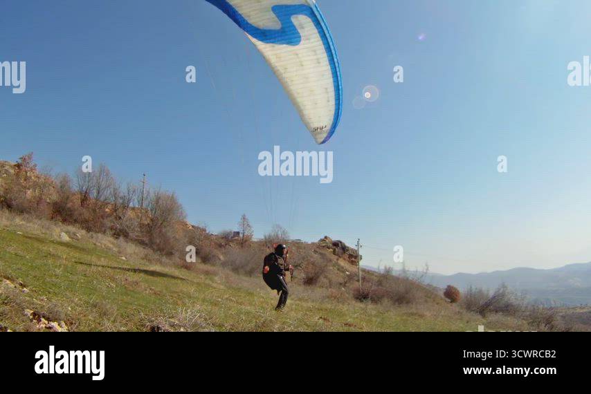 Paraglider taking off from a mountain range Stock Video Footage - Alamy