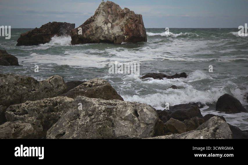 A strong storm on the sea at the precipitous shore, waves break against ...