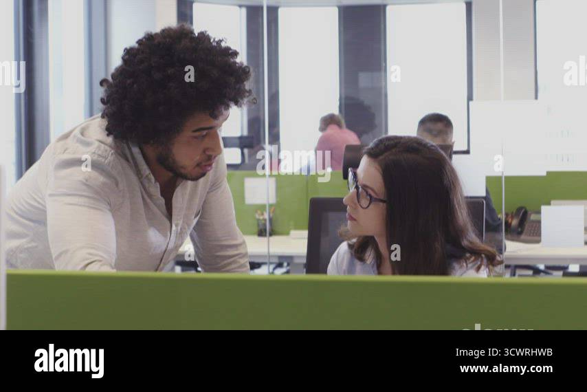 Typical office scene businessman and businesswoman having a meeting at ...