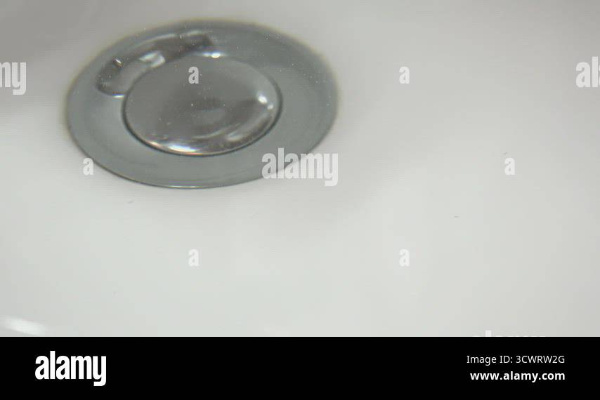 Bathroom Water swirls down a sink drain Stock Video Footage - Alamy