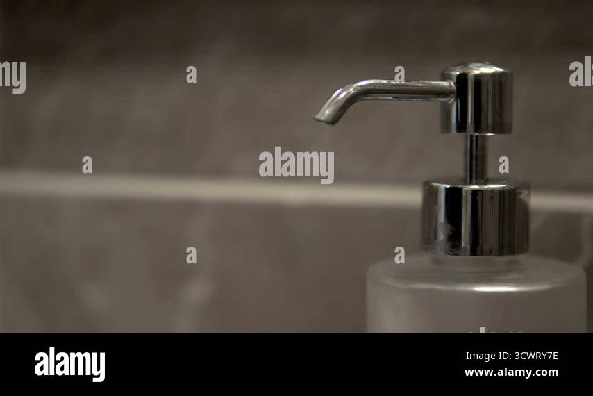 A hand soap with pumping lotion from bottle. Male hands using wash hand ...