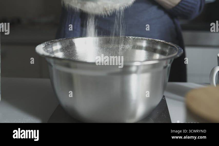 Sieving flour into a bowl Stock Video Footage - Alamy