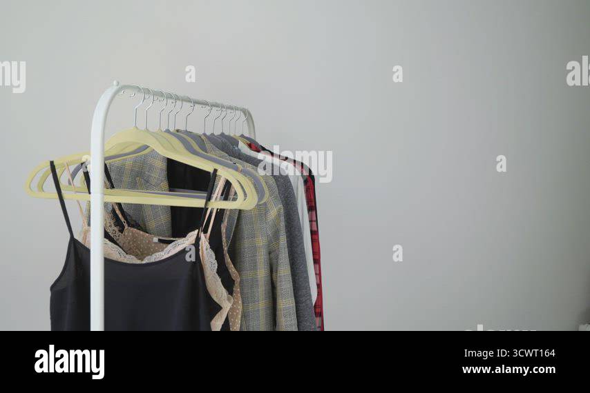Young woman choosing clothes on a rack searching what to wear. Store or ...