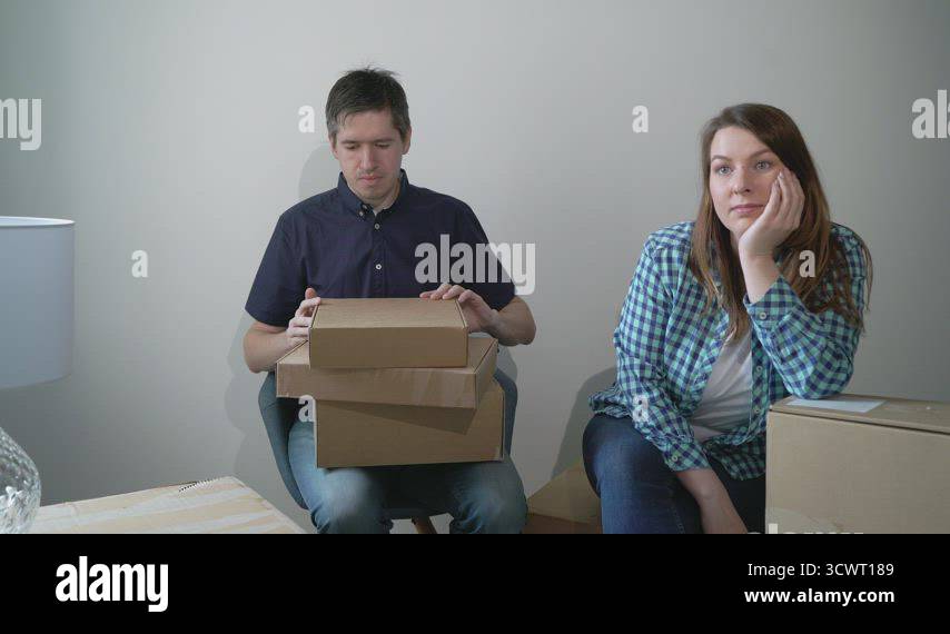 Young couple moving in new home. Sitting on floor and relaxing Stock ...
