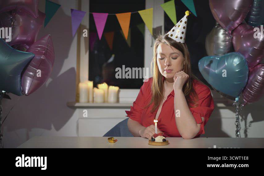 Young woman celebrating her birthday alone. Sad bored and tired girl ...