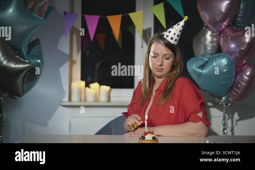 Young woman celebrating her birthday alone. Sad bored and tired girl ...